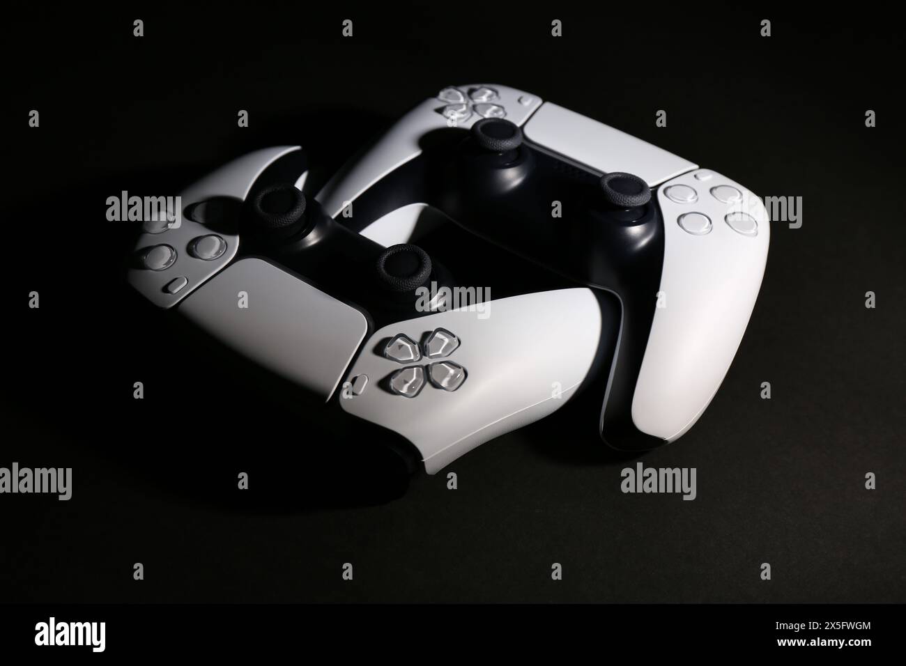 Two wireless game controllers on black background Stock Photo - Alamy