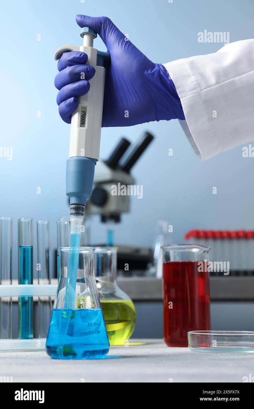 Laboratory analysis. Scientist dripping sample with micropipette into ...