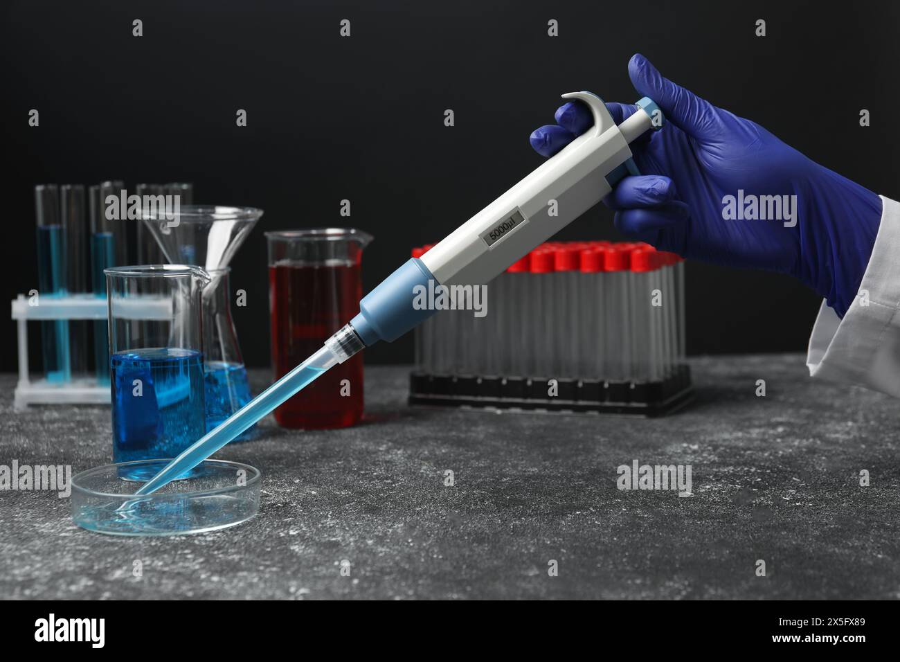 Laboratory analysis. Scientist dripping sample with micropipette into ...