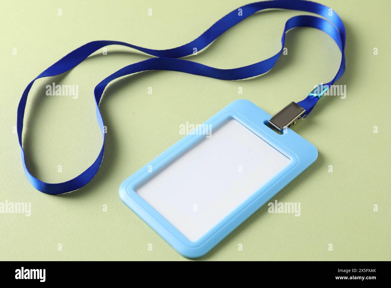 Blank light blue badge with string on green background Stock Photo - Alamy