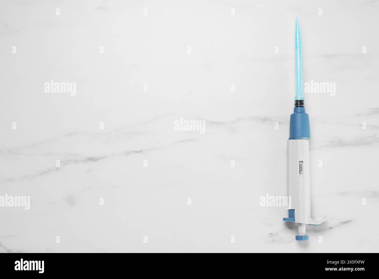 Laboratory analysis. Micropipette with liquid on white marble table ...