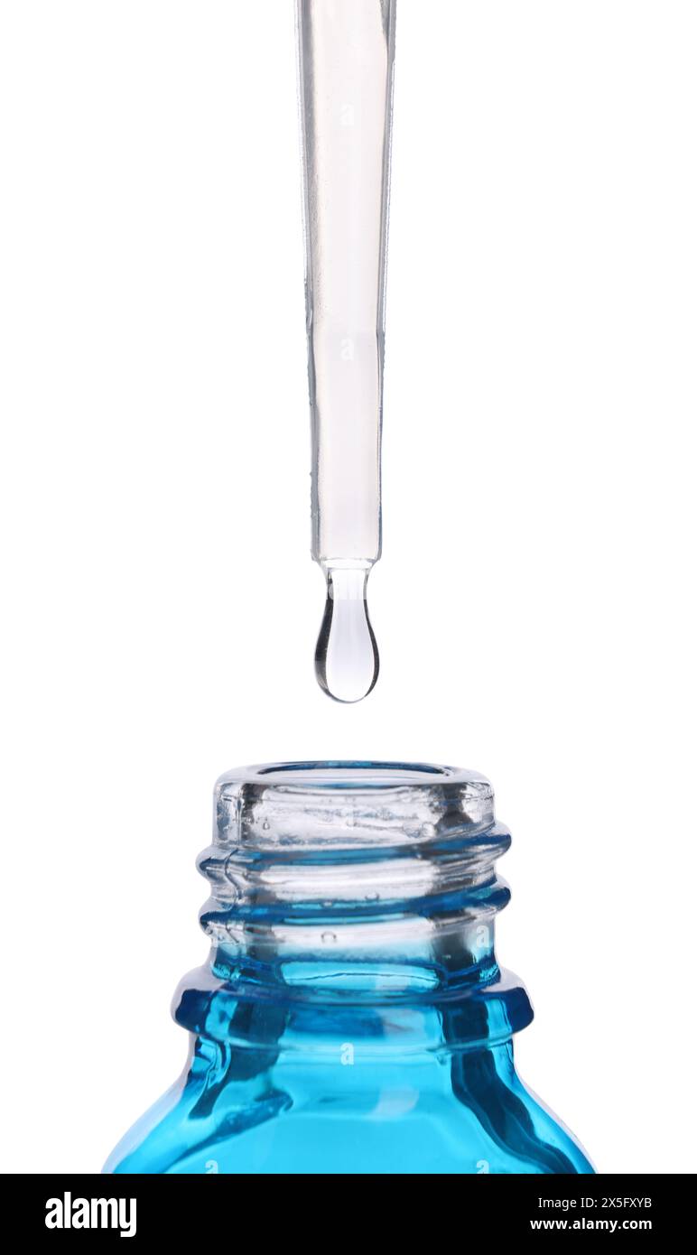 Dripping liquid from pipette into bottle isolated on white, closeup ...