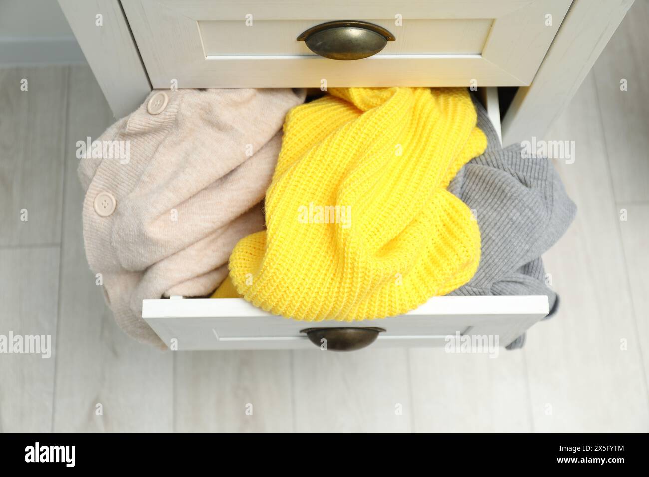 Cluttered chest of drawers indoors. Clothes in mess Stock Photo - Alamy