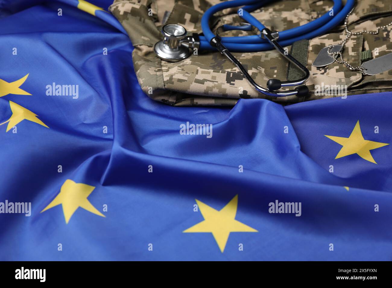 Stethoscope and military uniform on flag of European Union, closeup ...