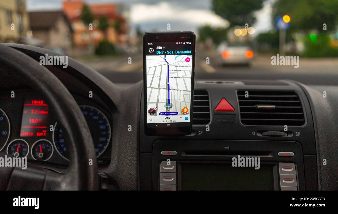 Smartphone showing Waze maps to show the way thru the city. Driver ...