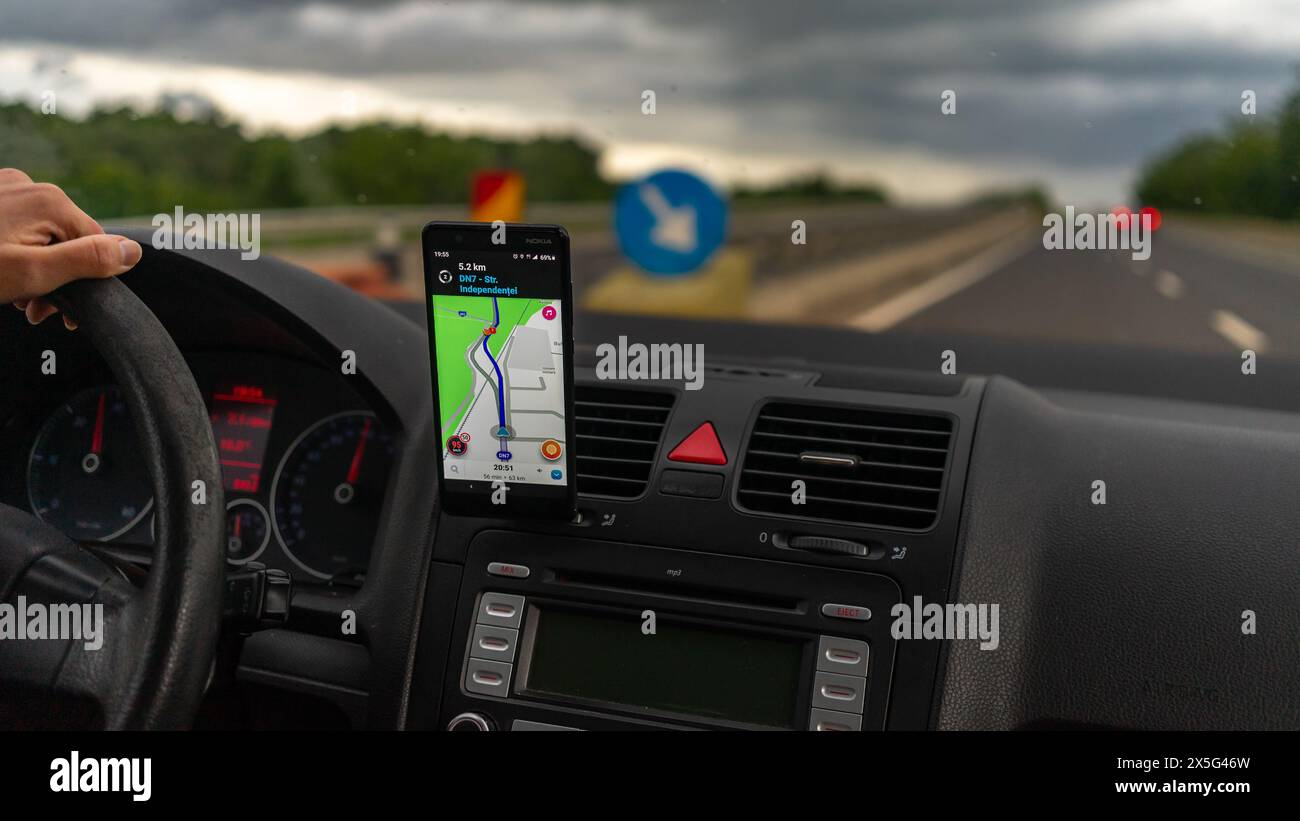 Smartphone showing Waze maps to show the way thru the city. Driver ...