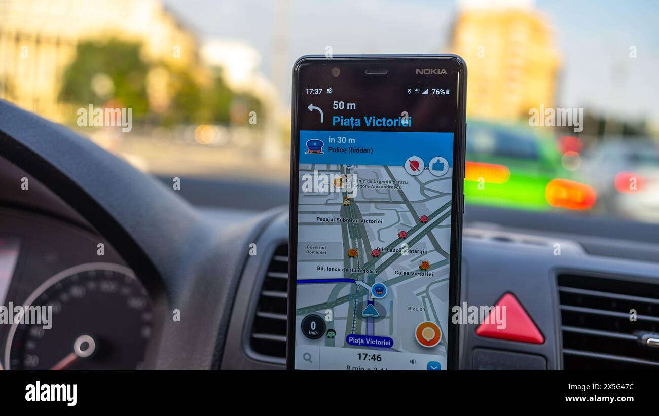 Smartphone showing Waze maps to show the way thru the city. Driver ...