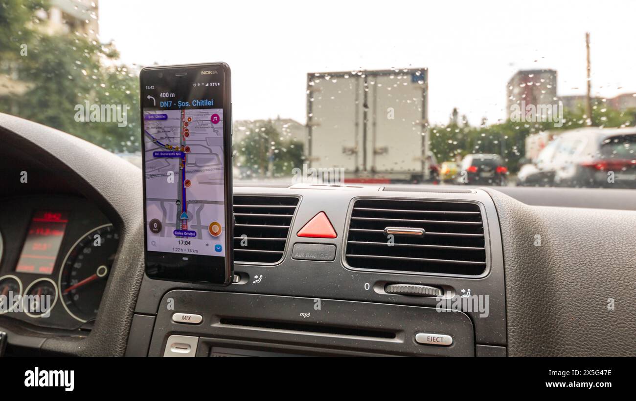 Smartphone showing Waze maps to show the way thru the city. Driver ...