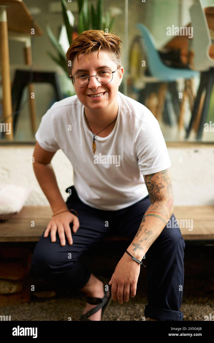 Confident transgender male smiles, casual attire, in modern office ...