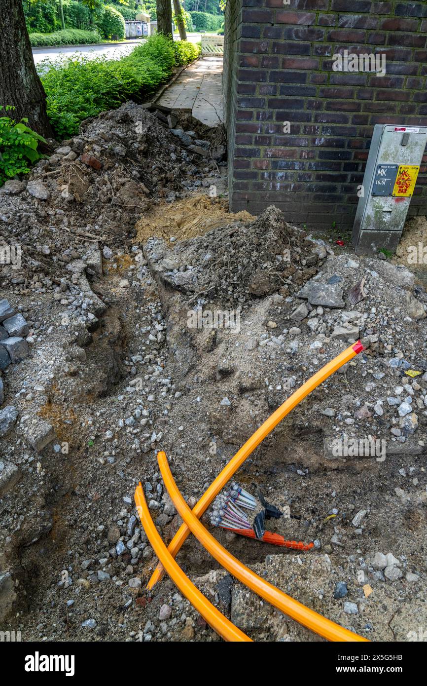 Laying of fiber optic cables, empty conduits are laid under a sidewalk ...