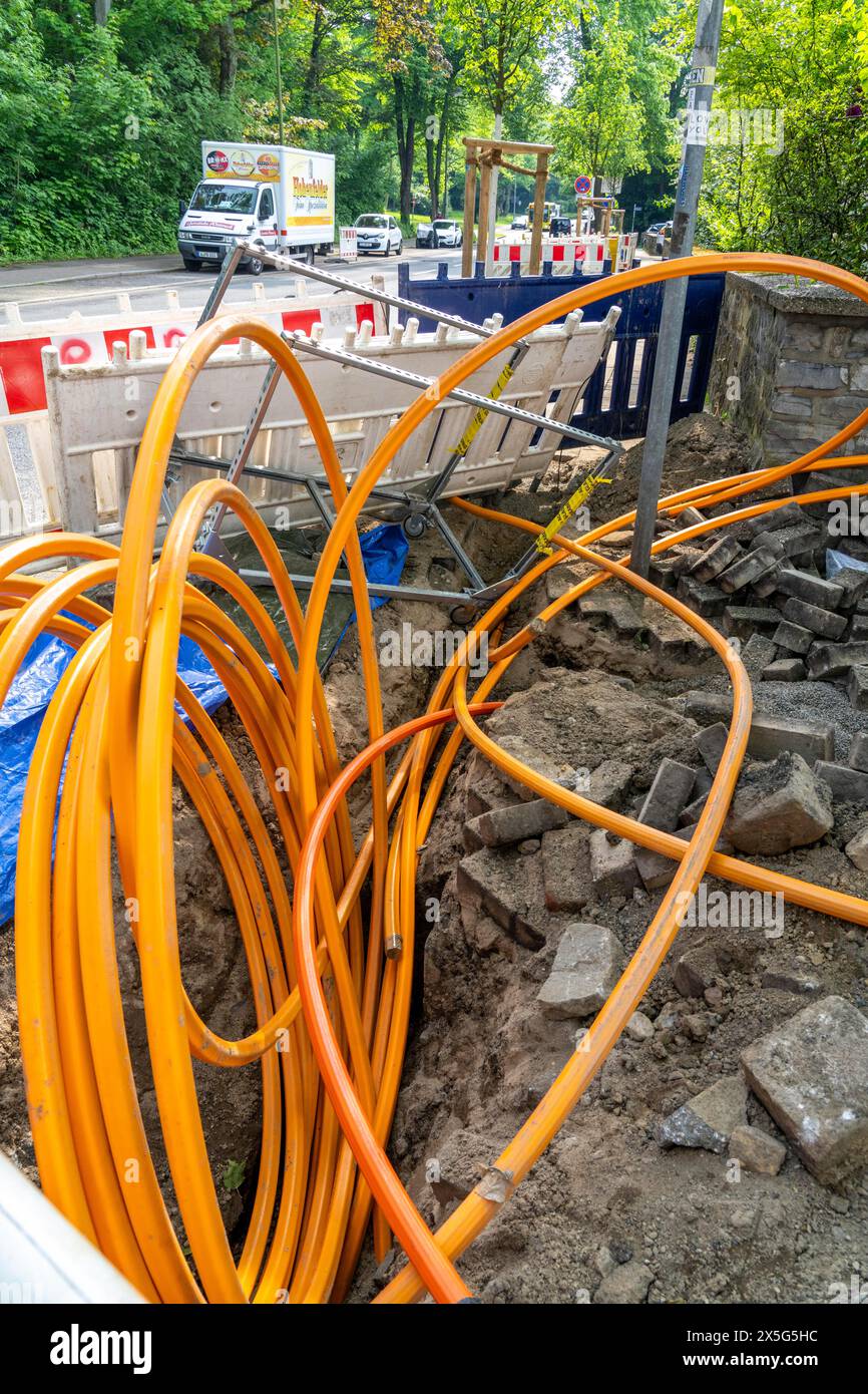 Laying of fiber optic cables, empty conduits are laid under a sidewalk ...