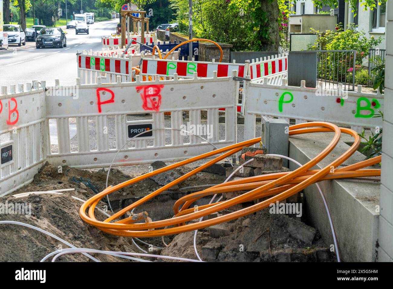 Laying of fiber optic cables, empty conduits are laid under a sidewalk ...