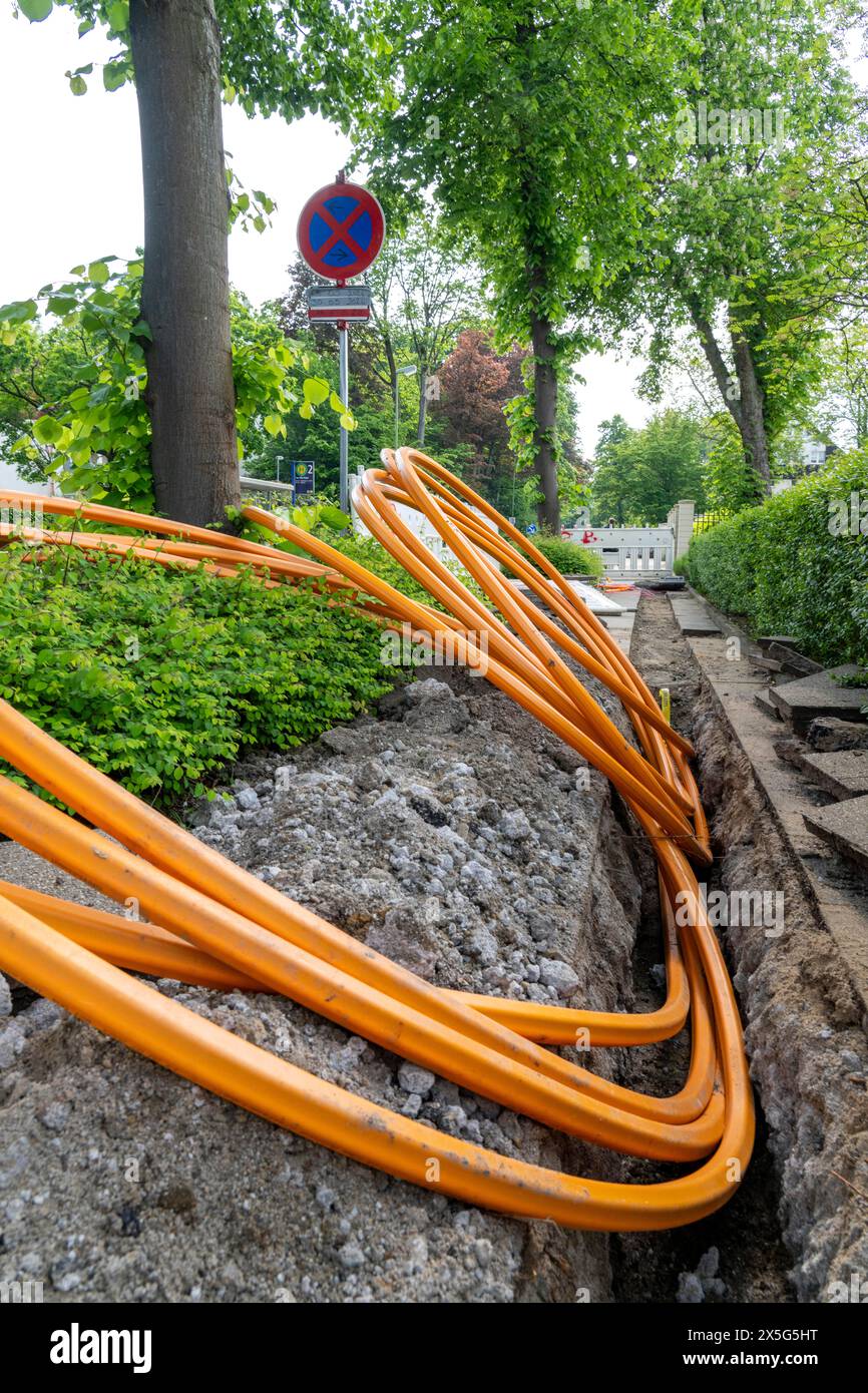 Laying of fiber optic cables, empty conduits are laid under a sidewalk ...