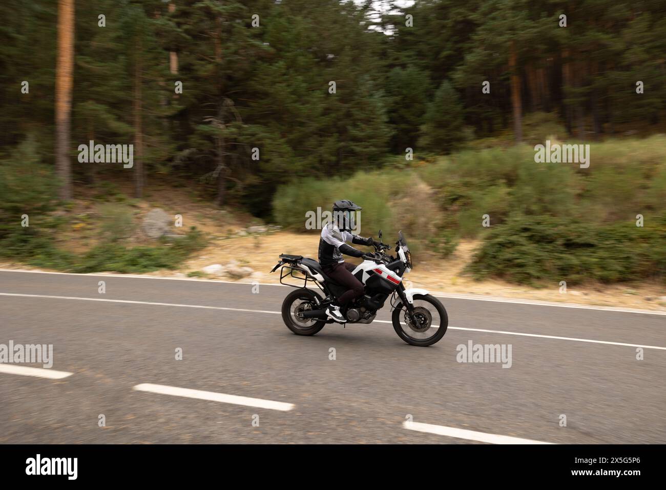 black-clad motorcyclist on motorcycle on the road with helmet on ...