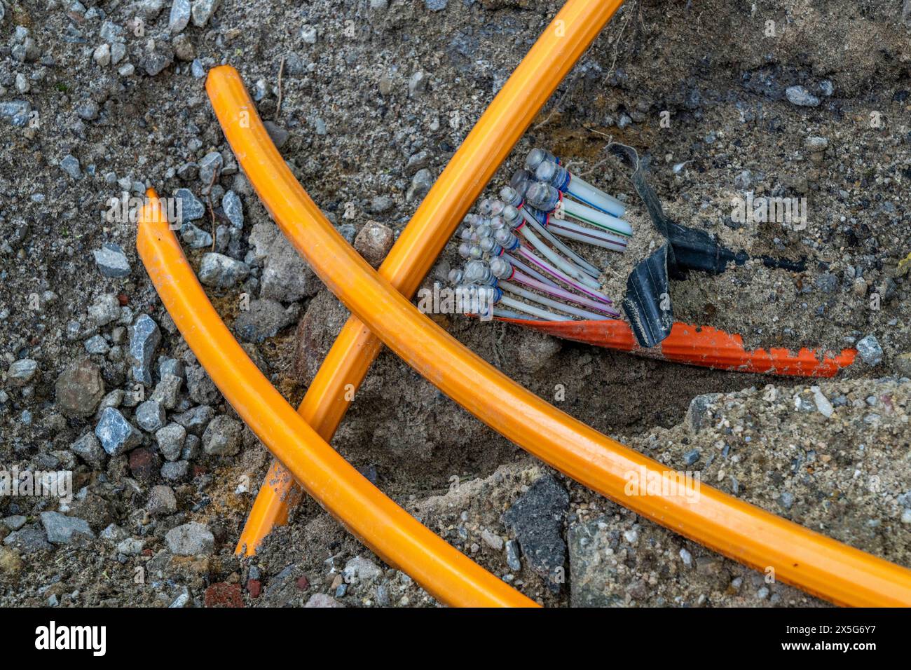Verlegung von Glasfaserkabeln, Leerrohre werden unter einem Gehweg ...