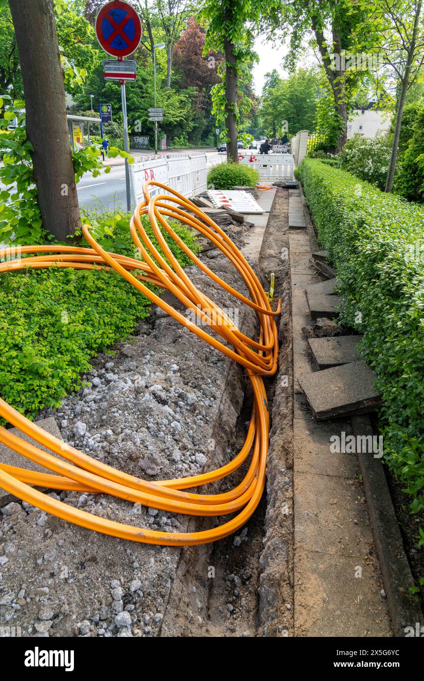 Verlegung von Glasfaserkabeln, Leerrohre werden unter einem Gehweg ...