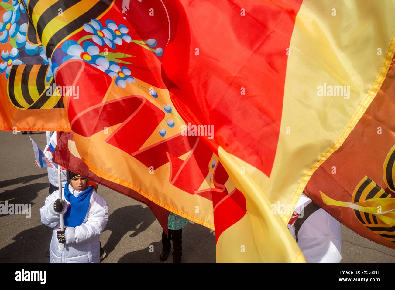 Moscow, Russia. 9th of May, 2024. Kids hold flags during a festive ...