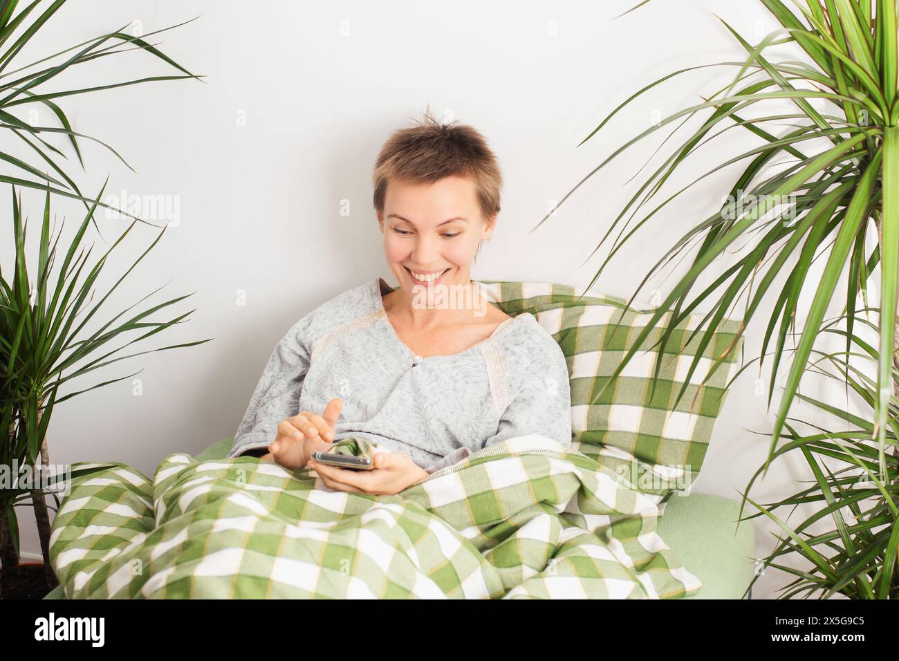 The middle-aged lady remains in bed, engrossed in her phone throughout ...