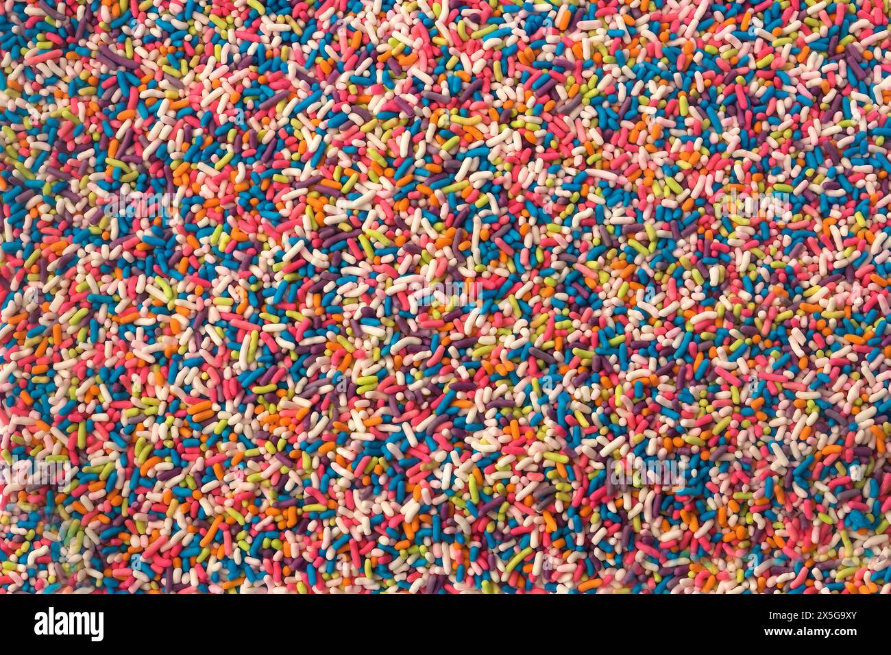 A pile of colorful scattered sprinkles creating a vibrant and cheerful ...