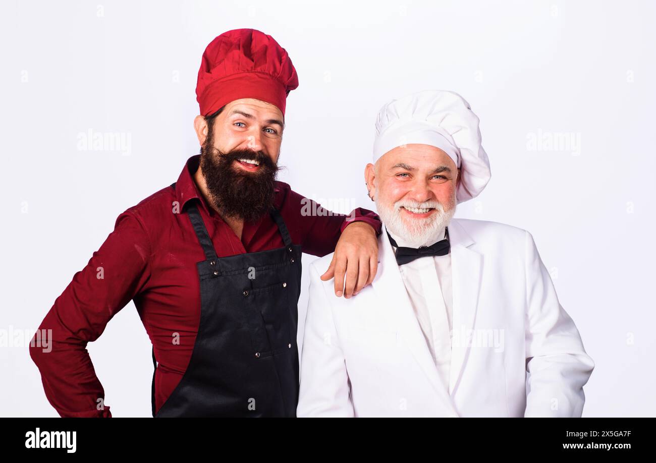 Two smiling chefs or cooks in uniform on kitchen. Chief cook and ...