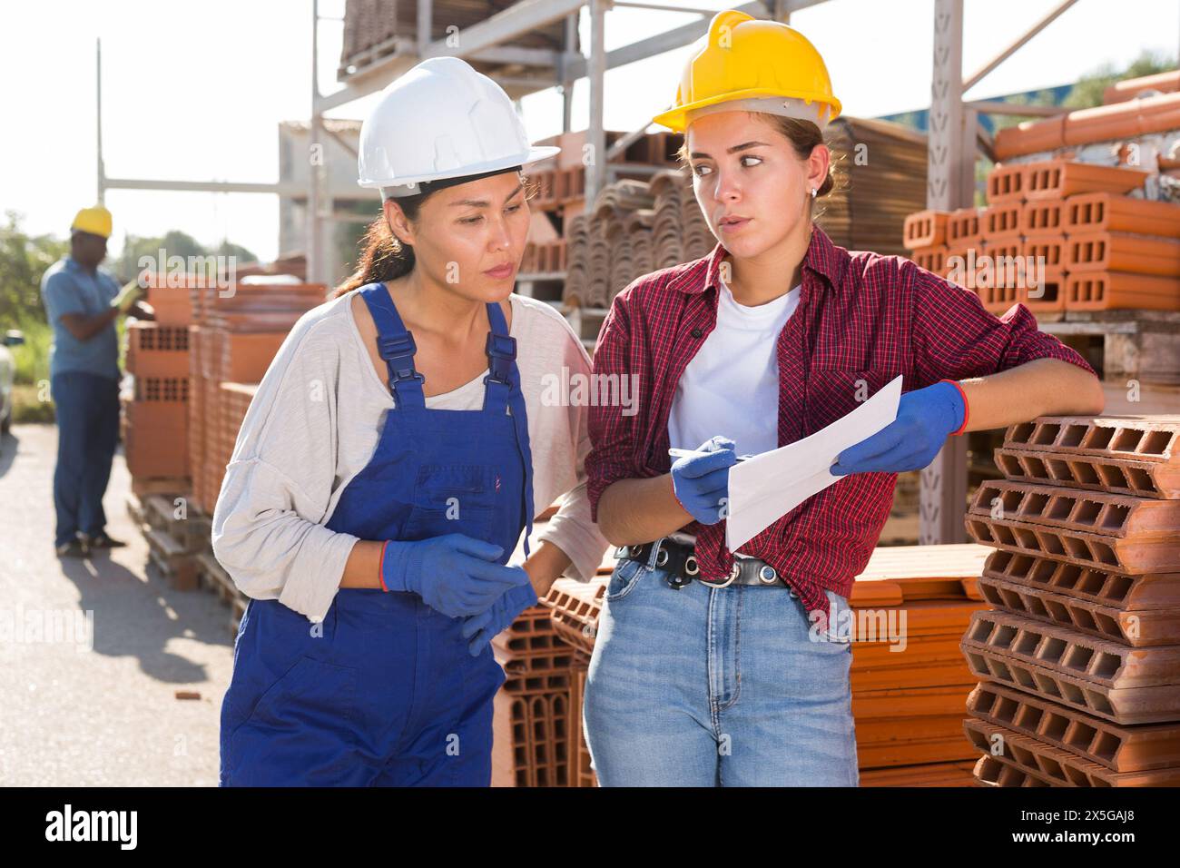 Two managers are discussing work plan at site of an open-air ...