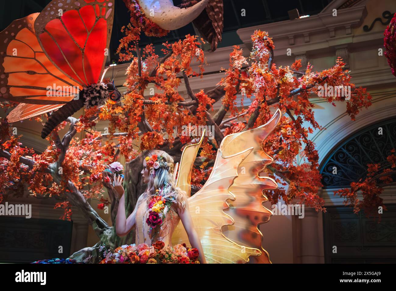 Whimsical fairy figure with golden wings in enchanted indoor display ...
