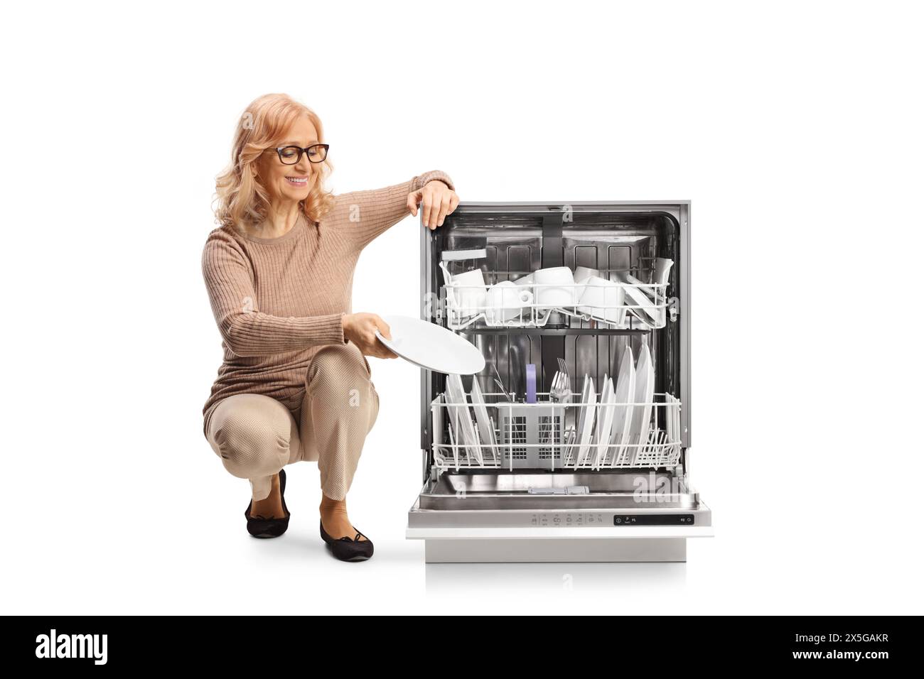 Woman putting a plate into a dishwasher isolated on white background ...