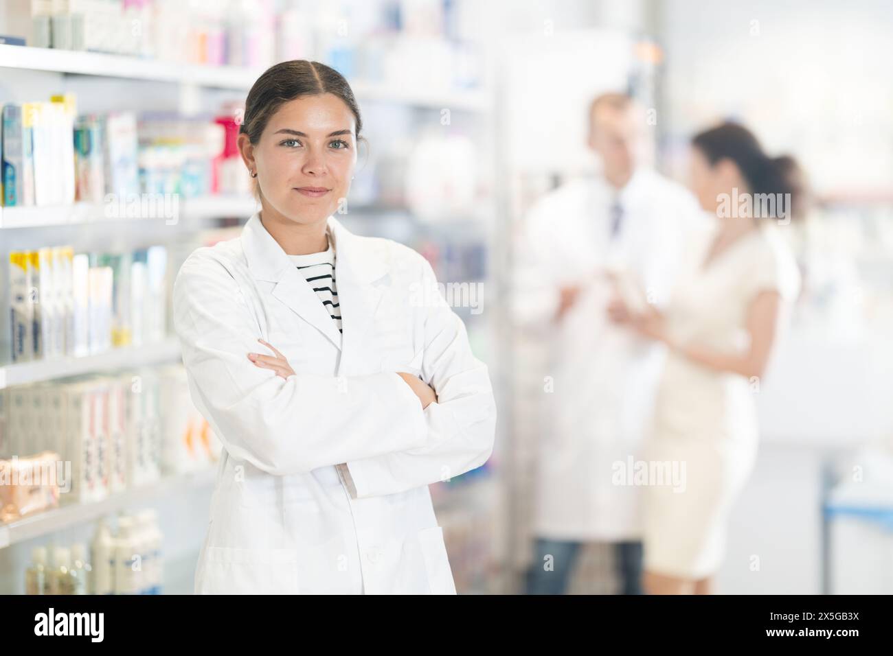 Female pharmacist in medical uniform posing while working in pharmacy ...