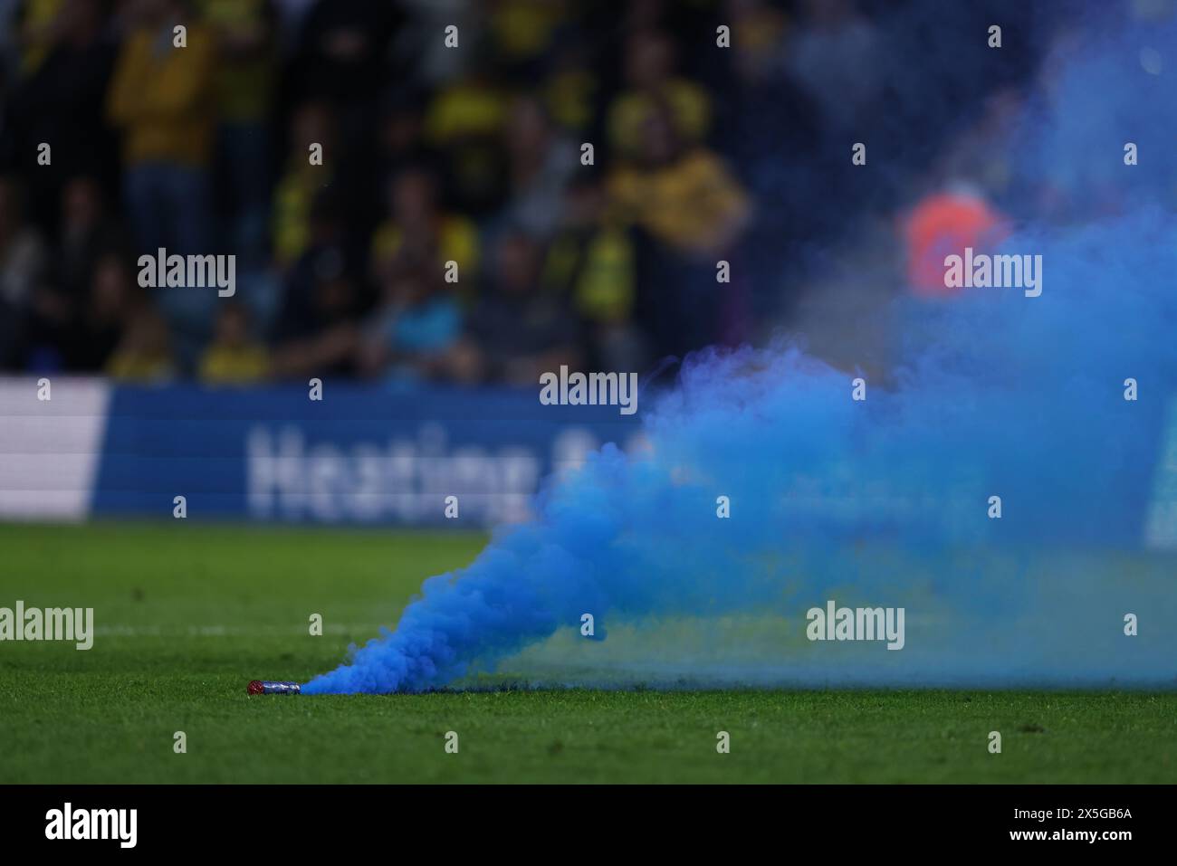 Peterborough, UK. 08th May, 2024. A blue flare thrown onto the pitch at ...