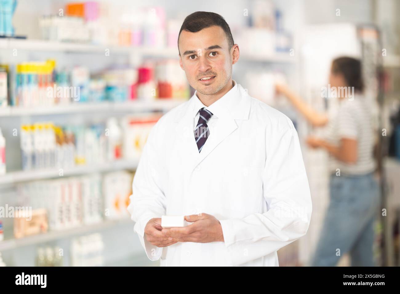 Positive male pharmacist in medical uniform posing while working in ...