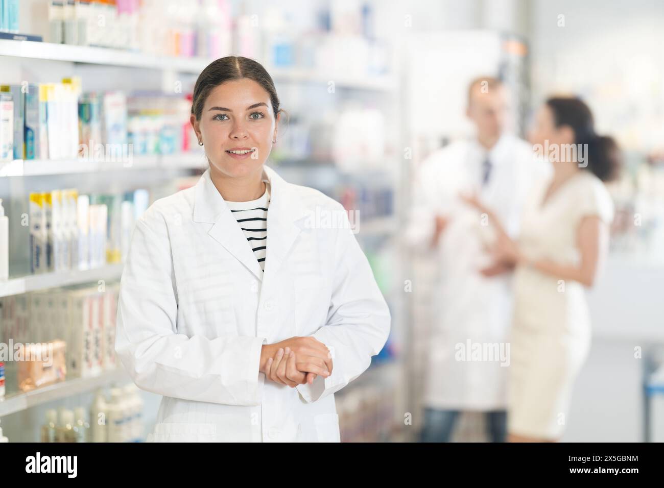 Female pharmacist in medical uniform posing while working in pharmacy ...