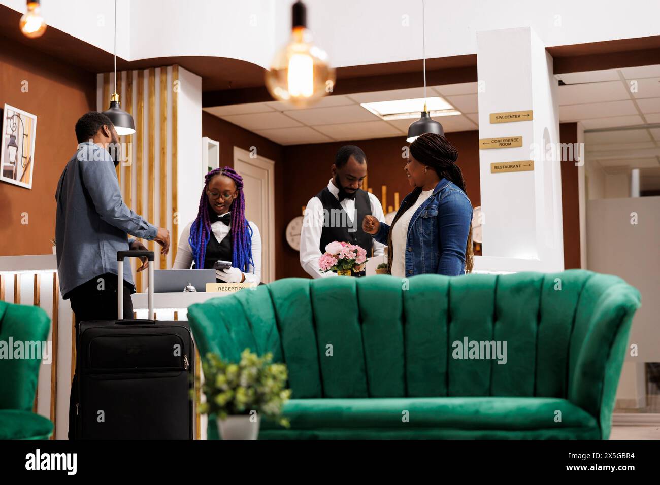 Happy young African American couple checking in at resort, arriving to ...