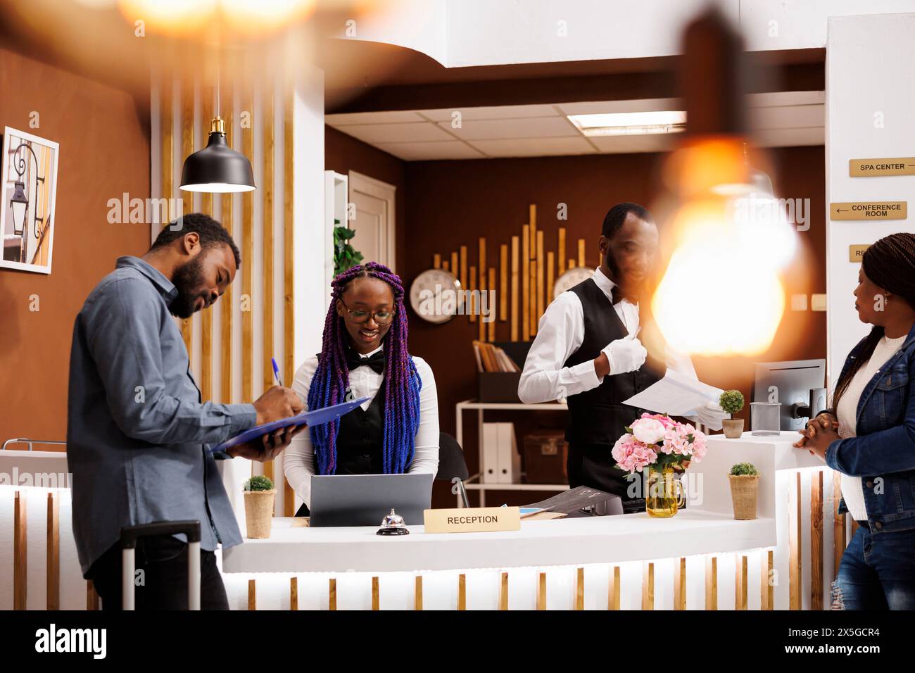 Young African American guy hotel guest filling up registration form at ...