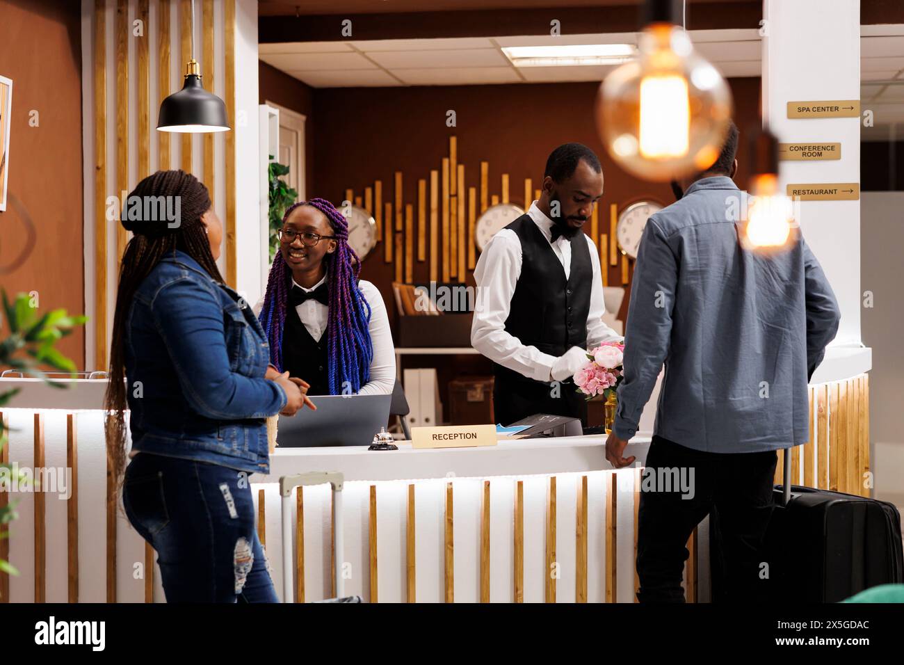 Friendly smiling front desk staff welcoming visitors at reception area ...