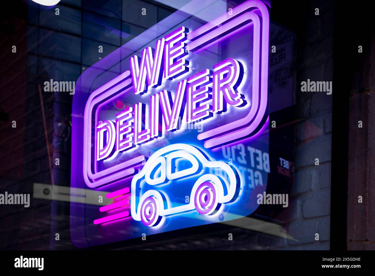 We deliver neon sign car logo in manchester uk Stock Photo - Alamy
