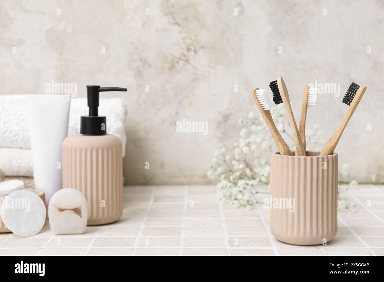Set of bath supplies with bamboo toothbrushes on light tile table Stock ...
