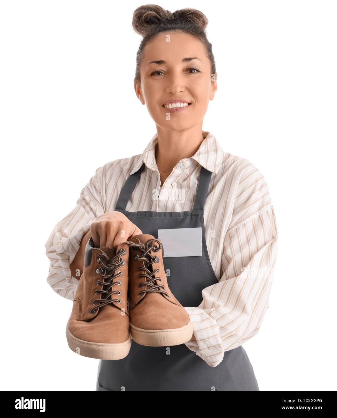 Happy female shoemaker with badge holding shoes on white background ...