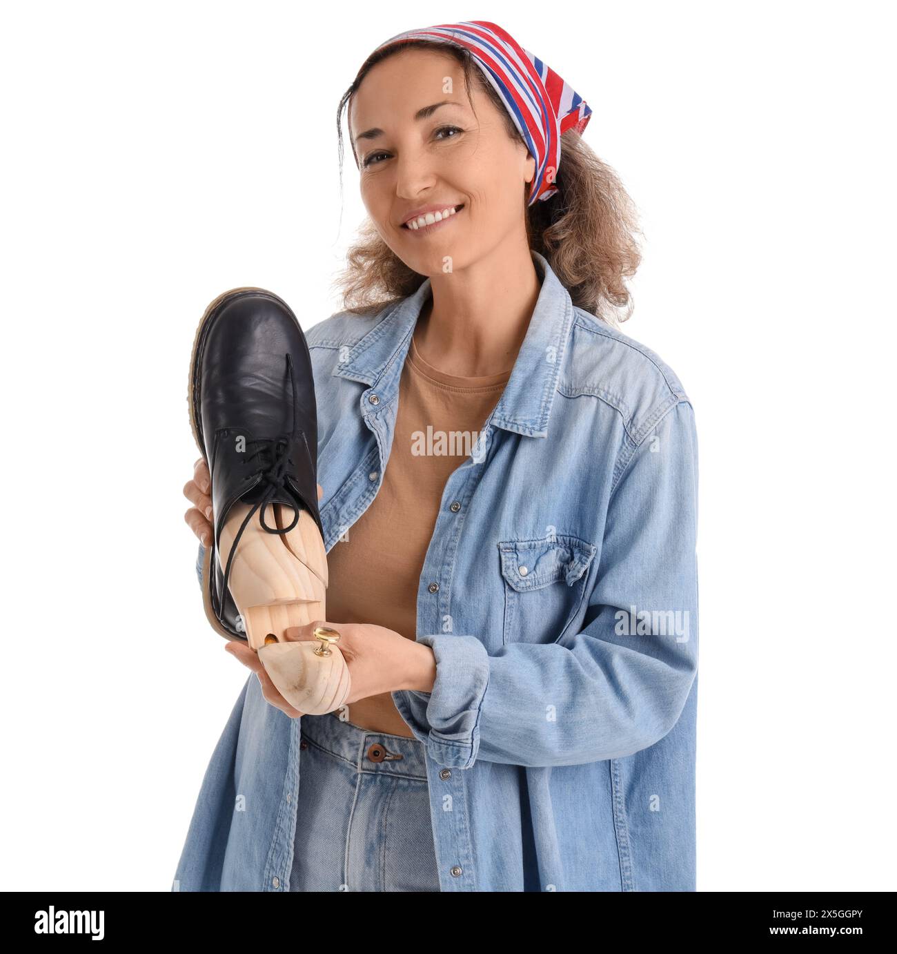 Happy female shoemaker with wooden shoe tree and boot on white ...