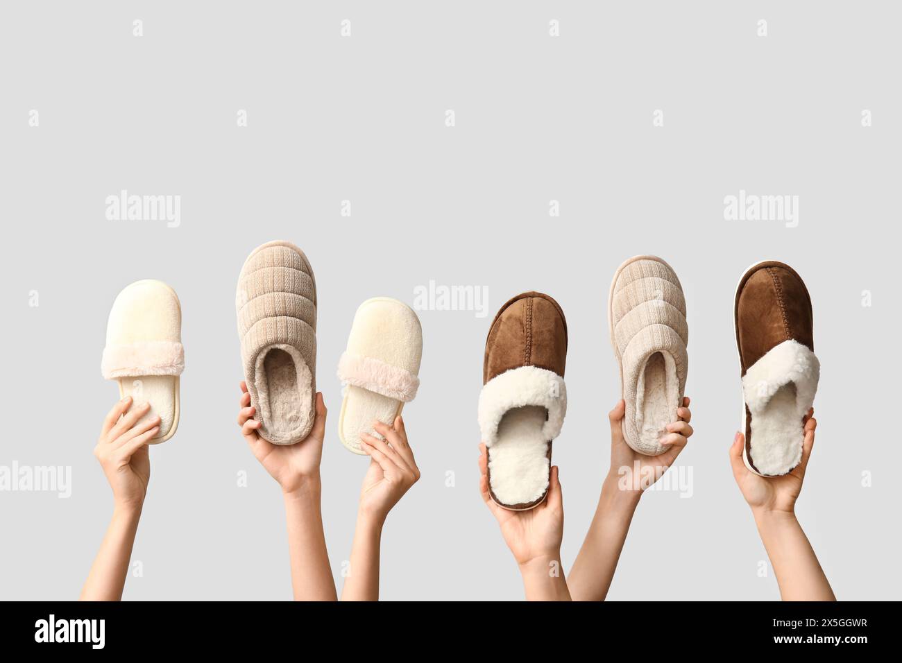 Female hands holding different slippers on white background Stock Photo ...