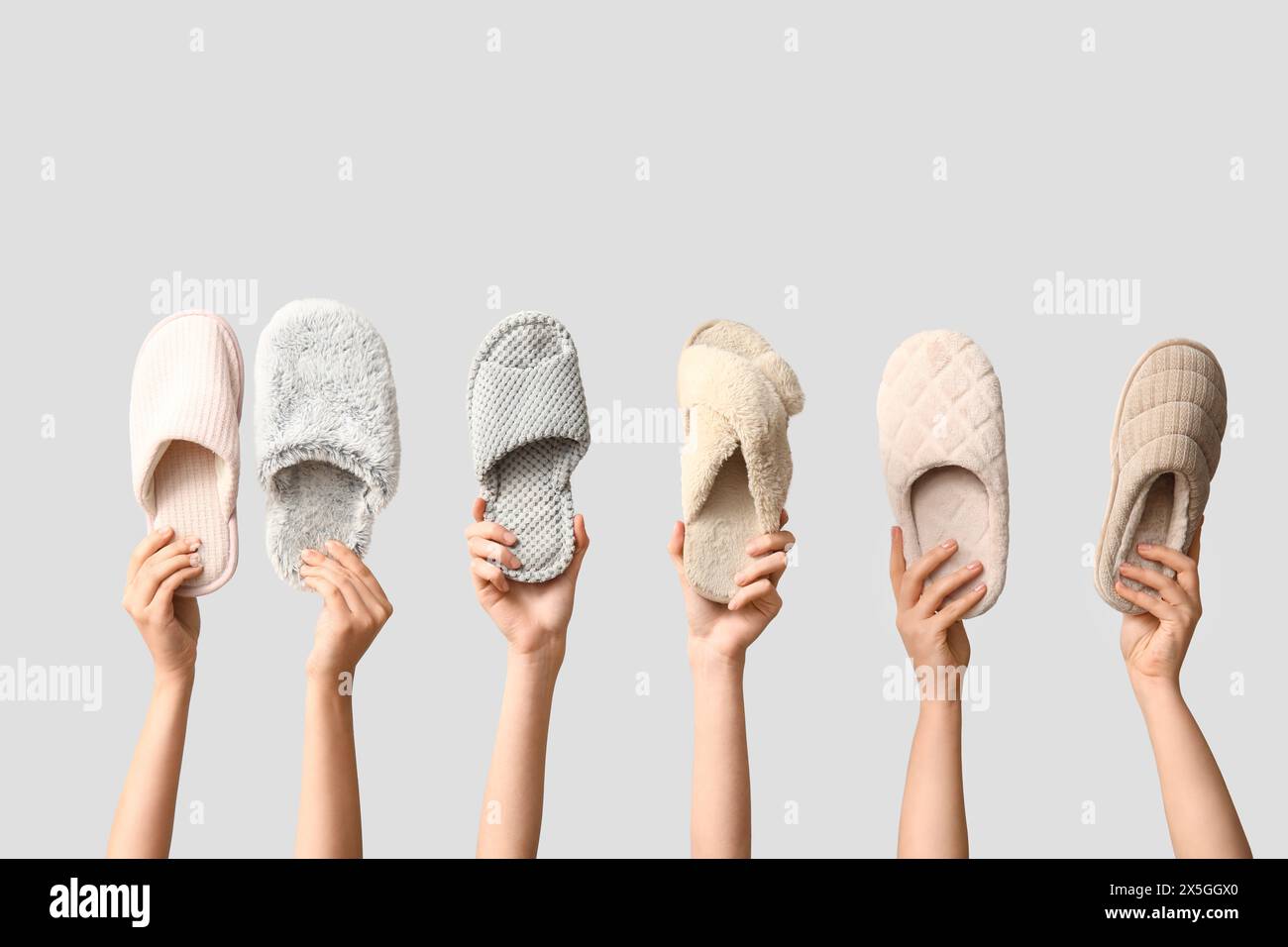 Female hands holding different slippers on white background Stock Photo ...