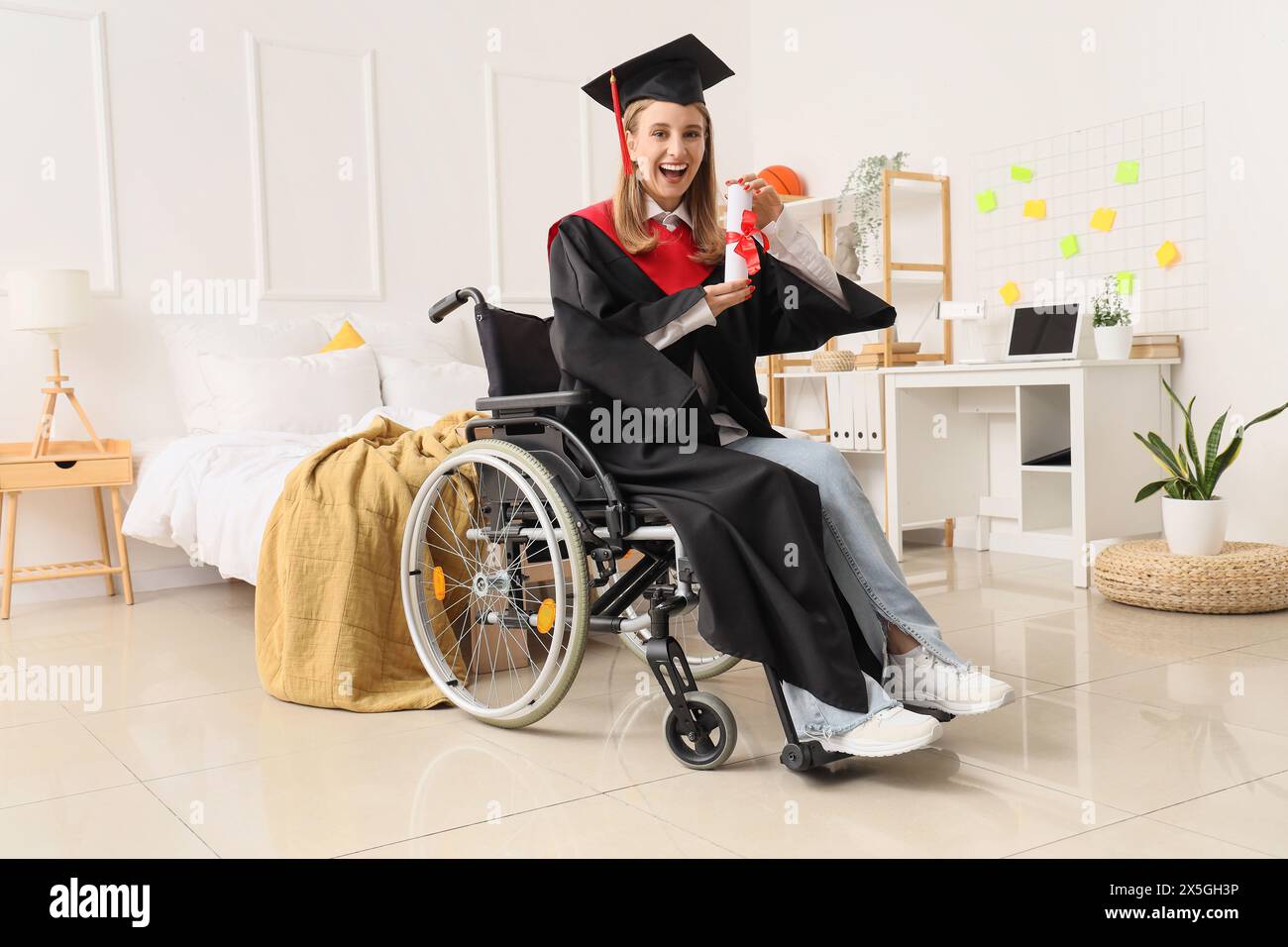 Happy female graduate in wheelchair with diploma at home Stock Photo ...