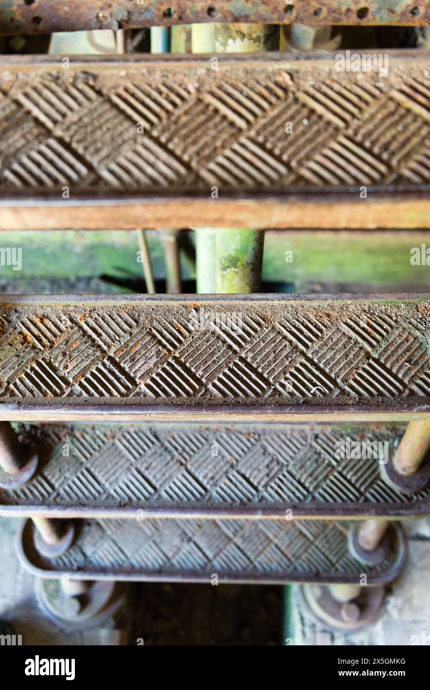 The stairs are old and rusted, with a pattern of squares and diamonds ...