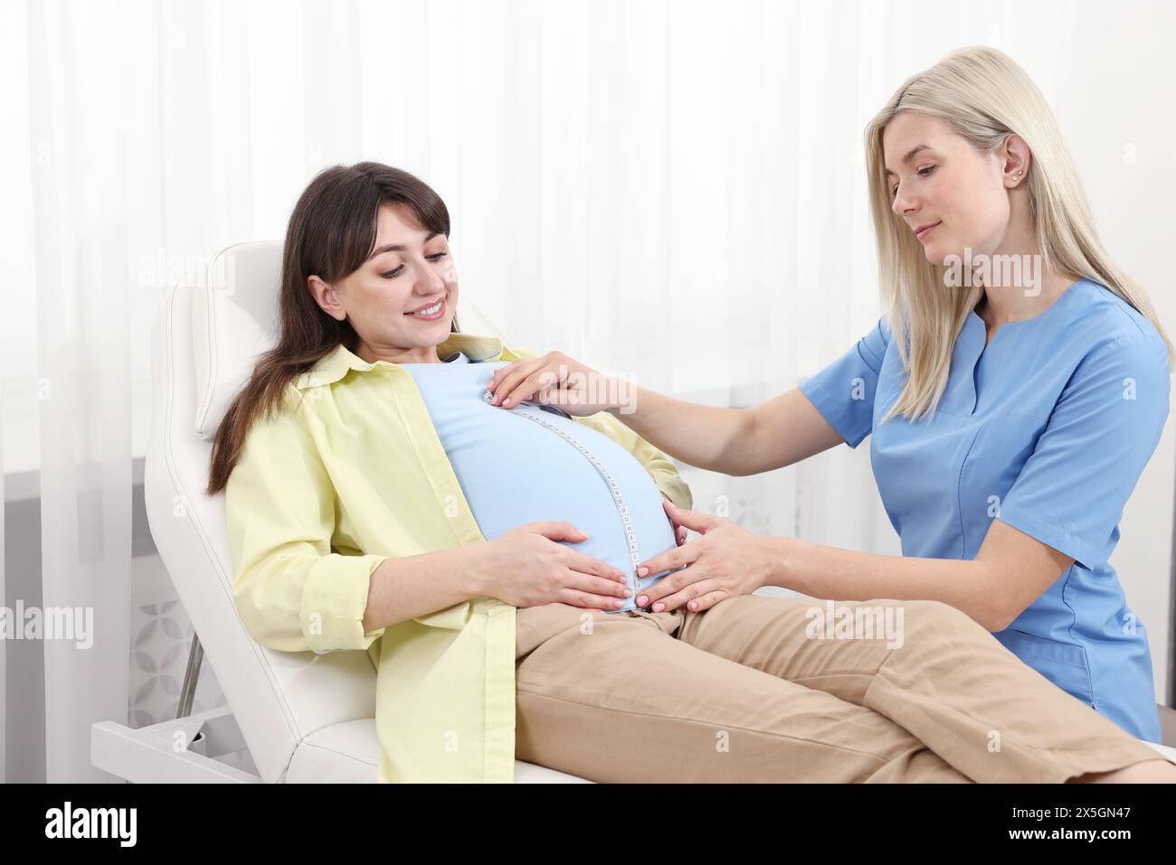 Pregnancy checkup. Doctor measuring patient's tummy in clinic Stock ...