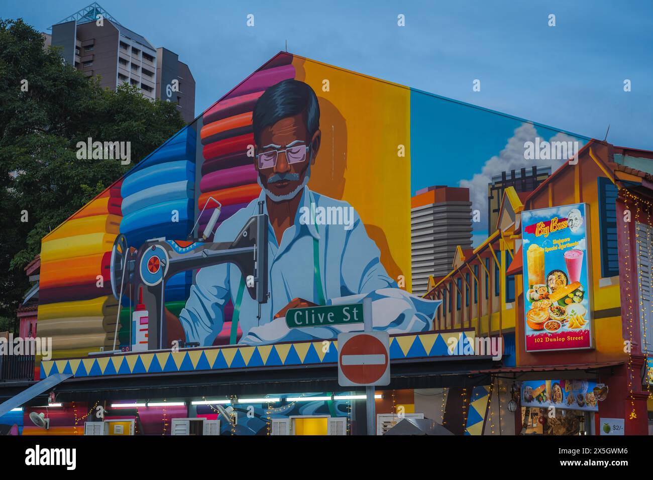 Vibrant mural depicting a man sewing, adorning a city building's facade ...