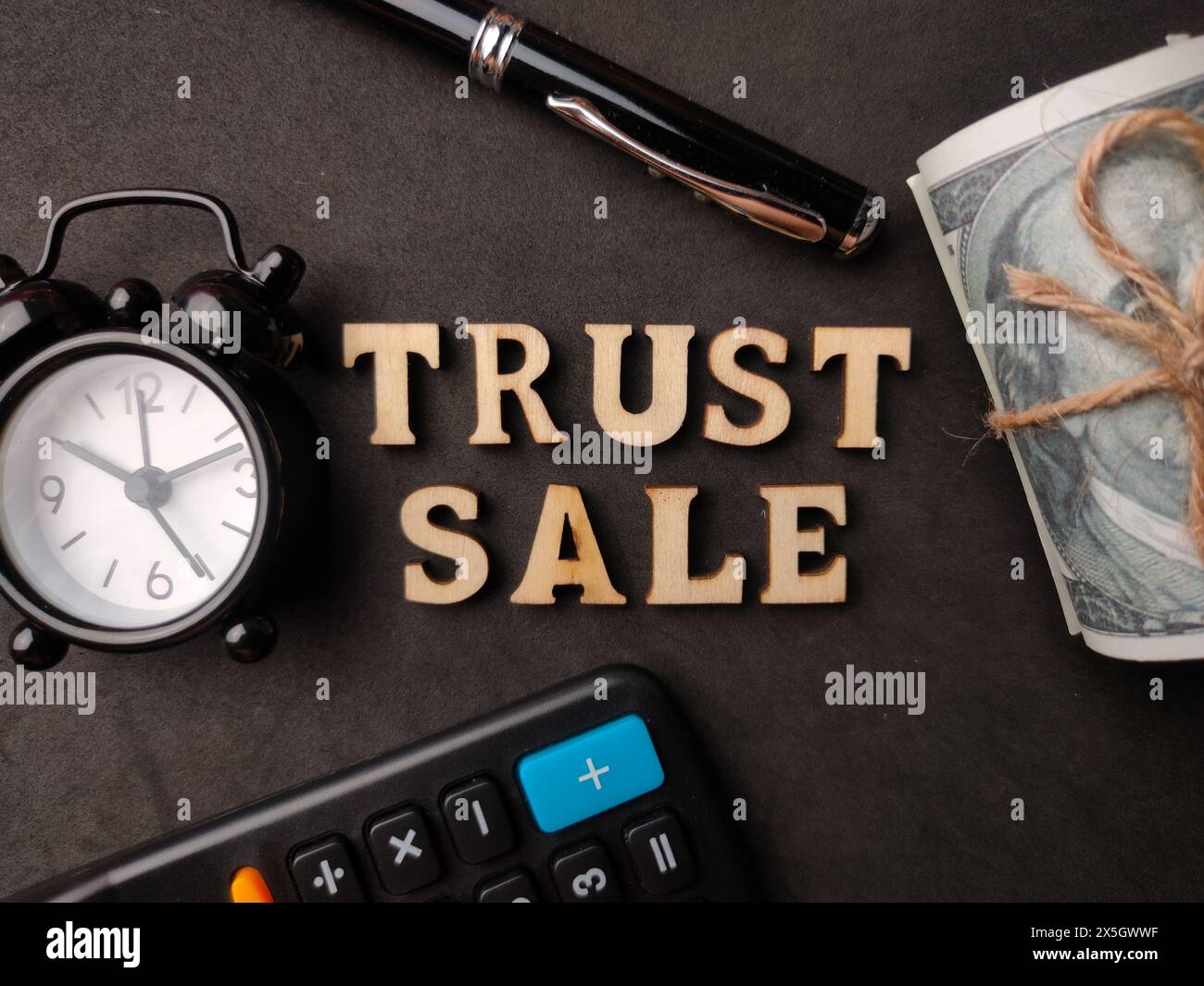 Top view calculator,pen,clock,banknotes and wooden word with text TRUST ...