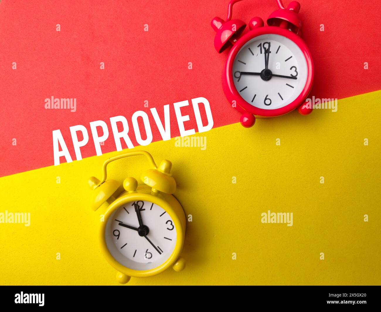 Top view alarm clock with text APPROVED on red and yellow background ...