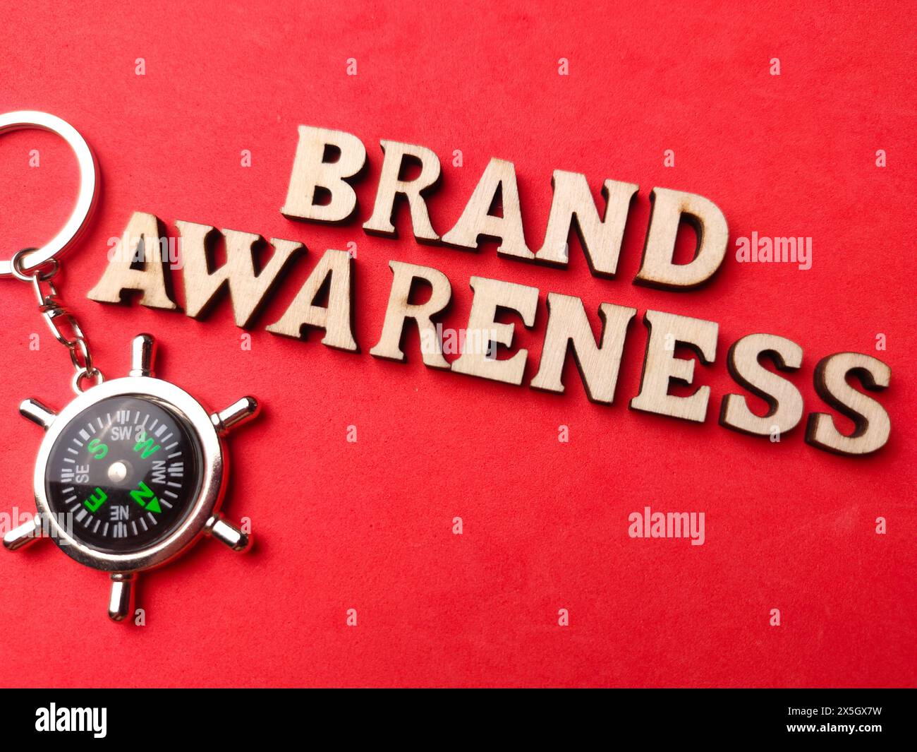 Top view compass and wooden word with text BRAND AWARENESS on red ...