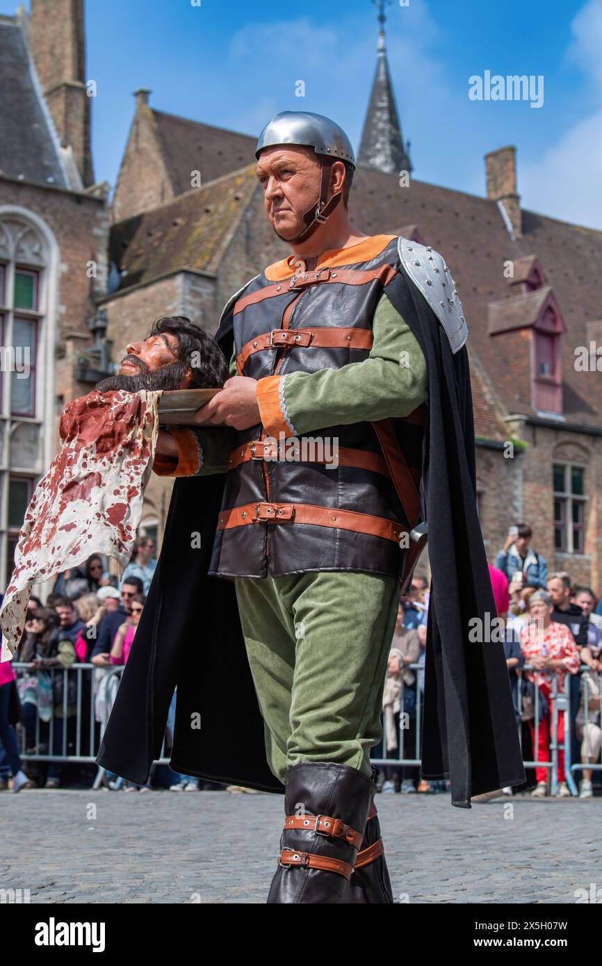 A man dressed as a soldier carries the head of John the Baptist during ...