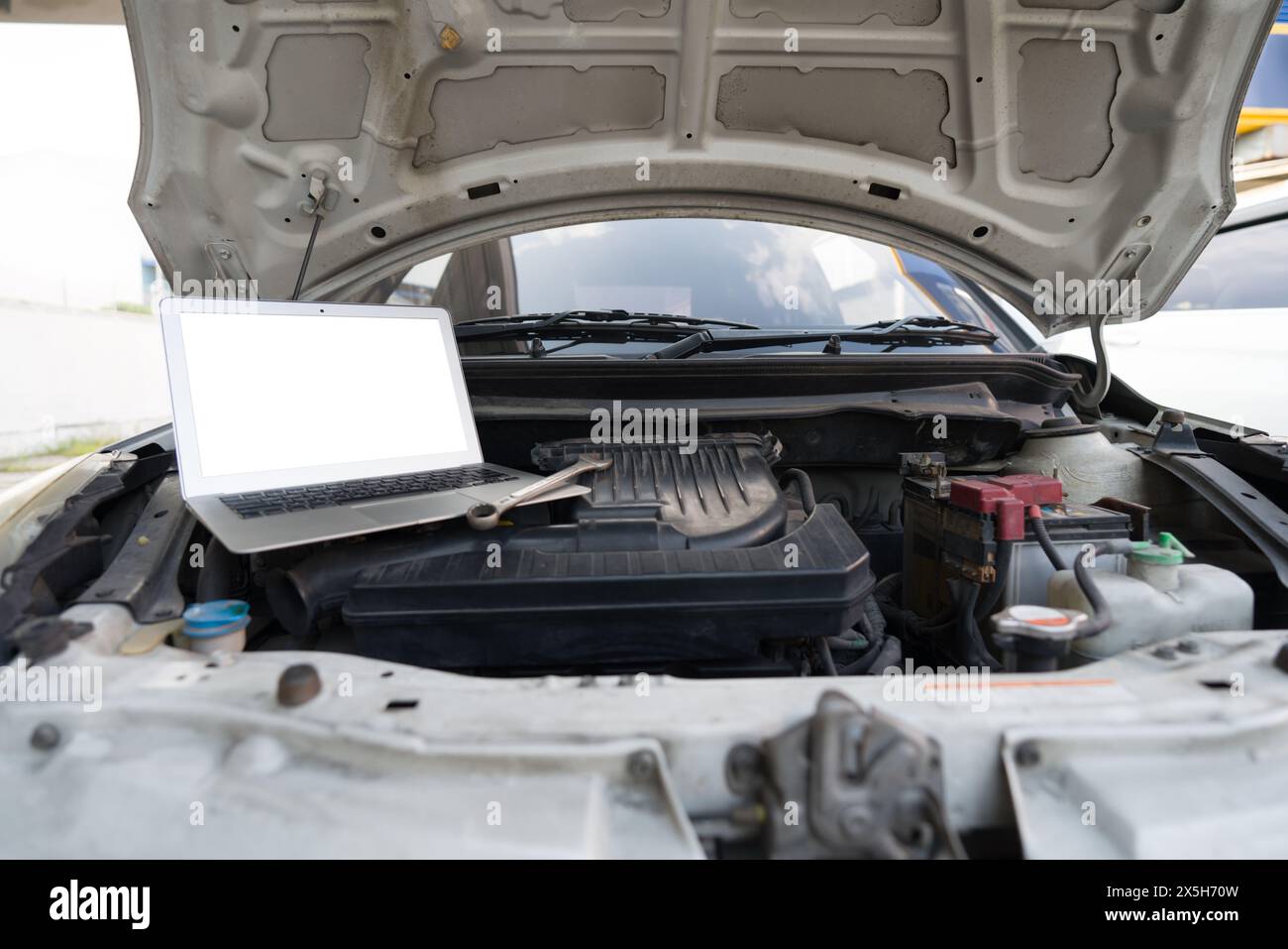 A blank screen laptop computer and wrench tool placing inside car's ...