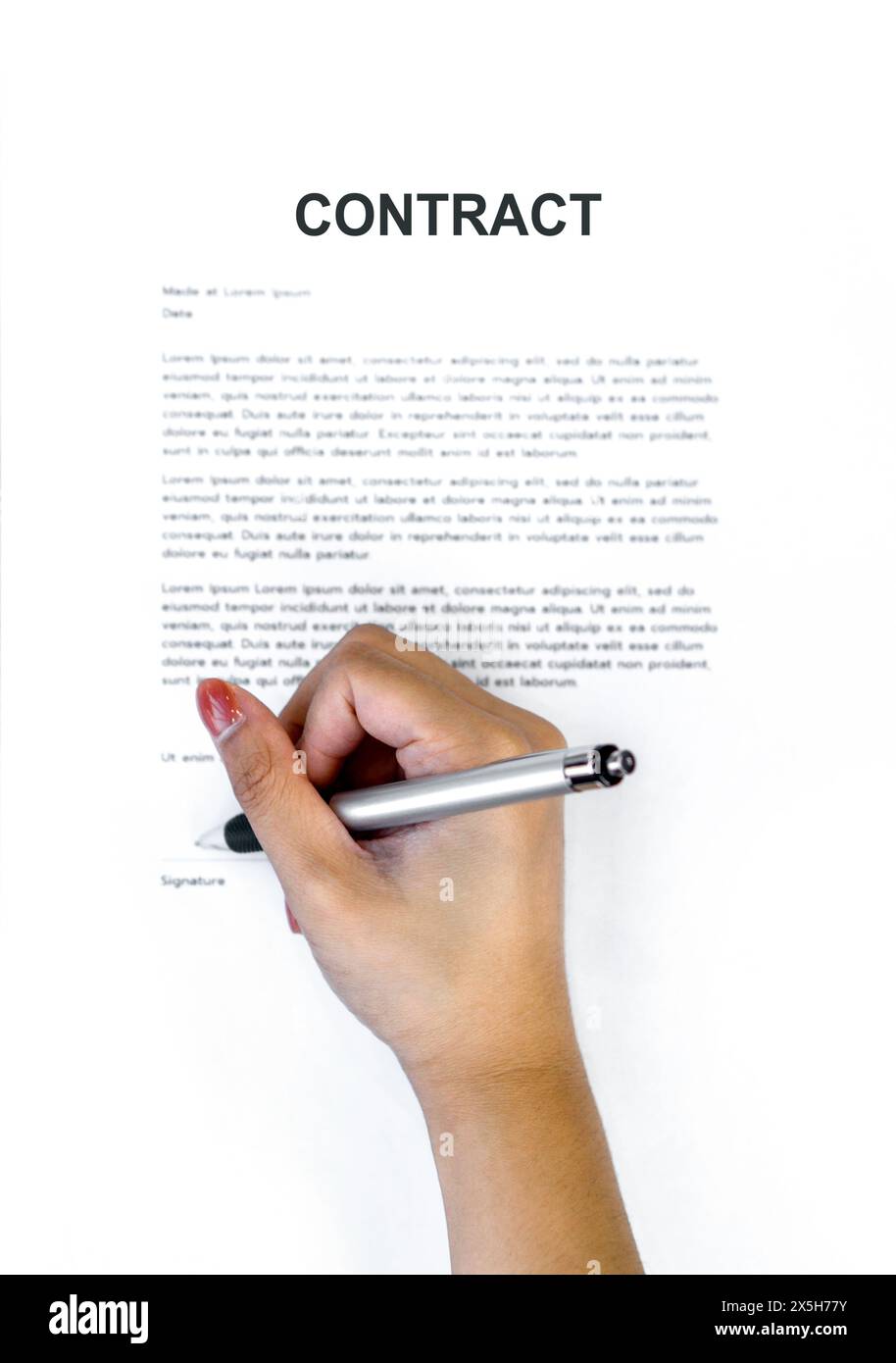 Closeup woman hand holding a pen signing her name on a CONTRACT ...